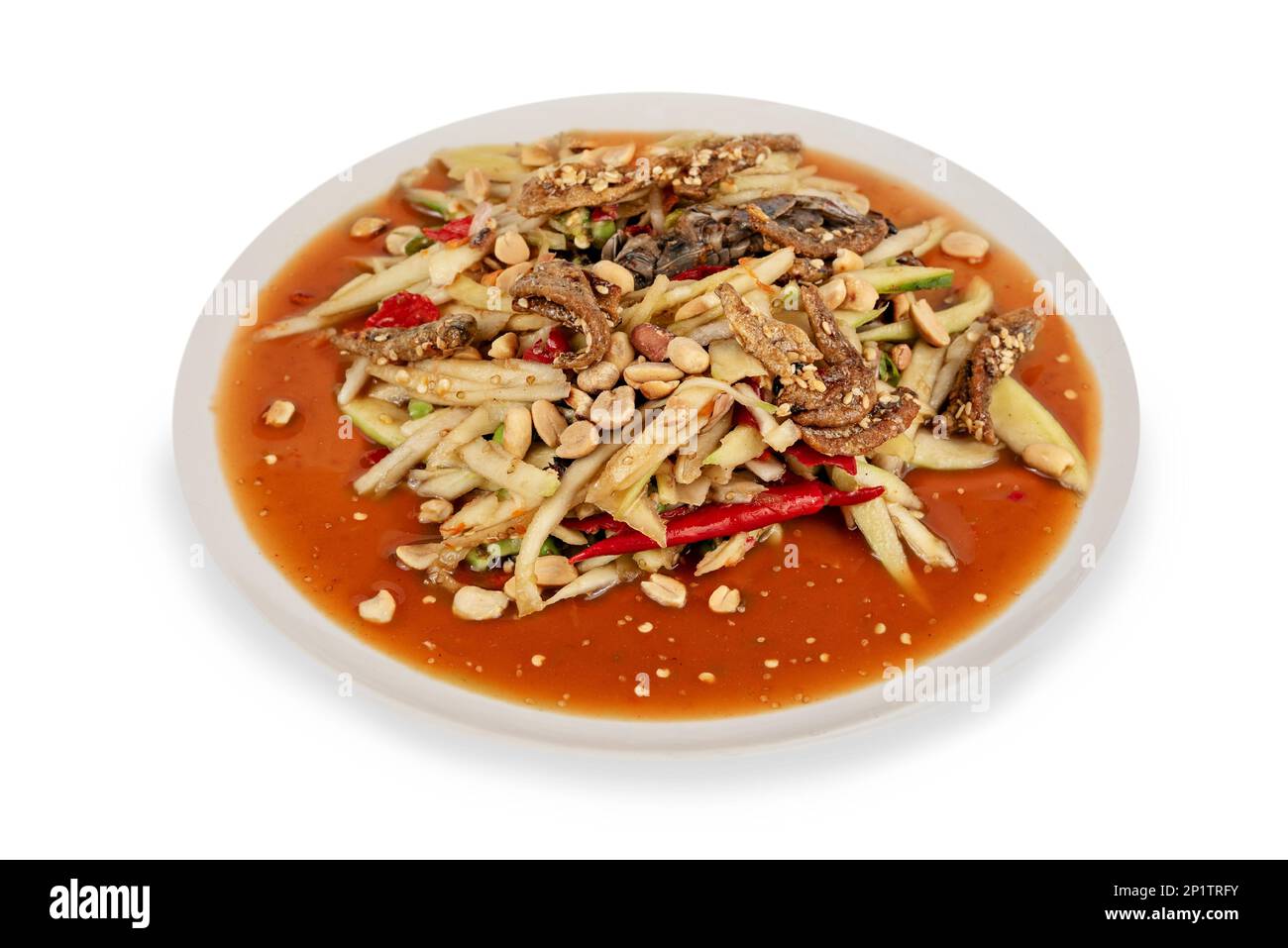 spicy green mango salad with crispy fish on dish over white background ...