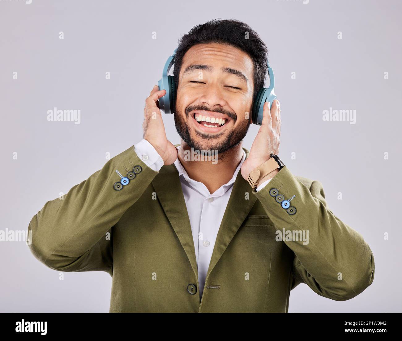 Music, headphones and business man singing in studio isolated on a gray ...