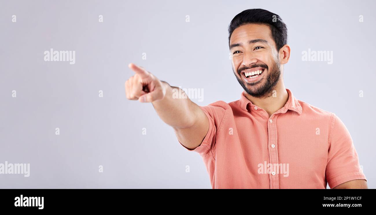 Happy, laughing and Asian man pointing for bullying isolated on a grey ...
