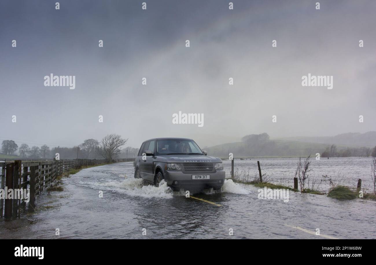 Range Rover driving on road flooded during heavy rain, Hawes ...