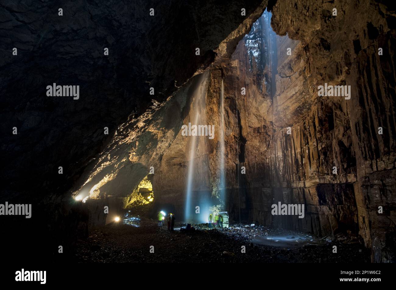 View of upland stream waterfall flowing down chasm into chamber of cave ...