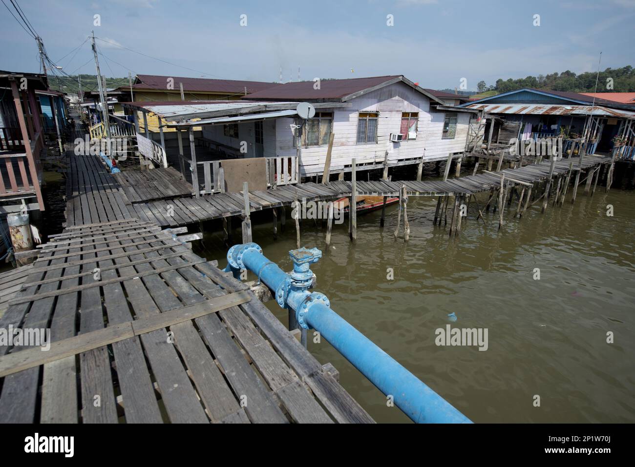 Walkway with blue hookah and huts on stilts in the river, water village ...