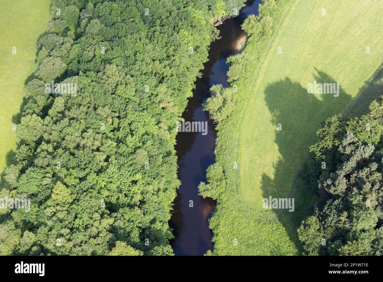 Aerial view of a river surrounded by woodland and flowing through ...