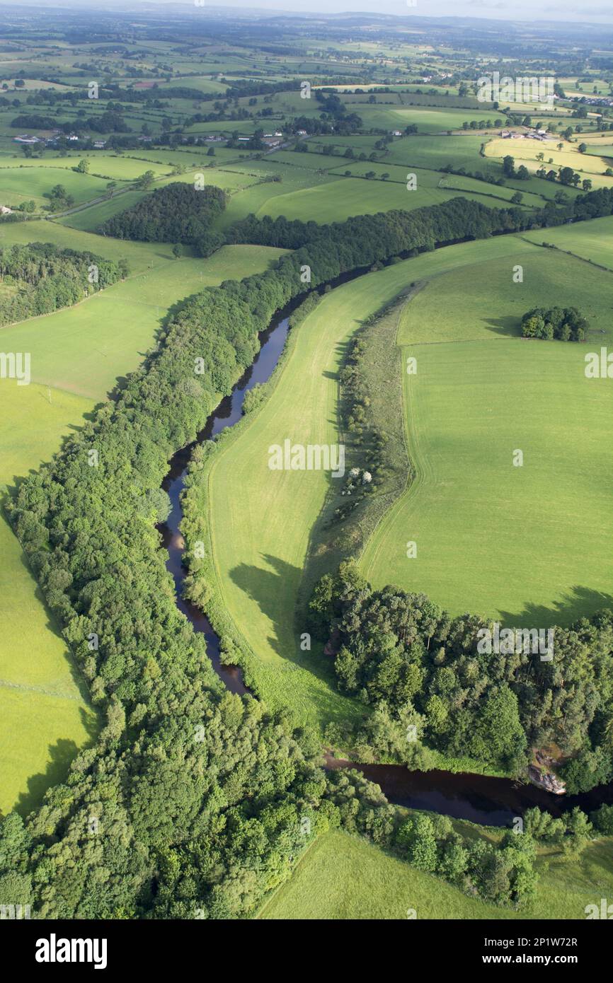 Aerial view of river lined with native woodland flowing through the ...