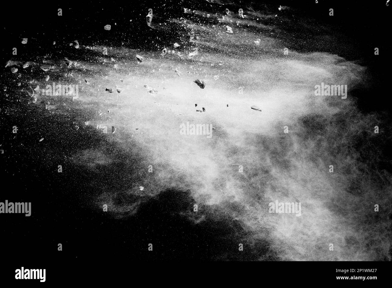 Split debris of stone exploding with white powder against black ...