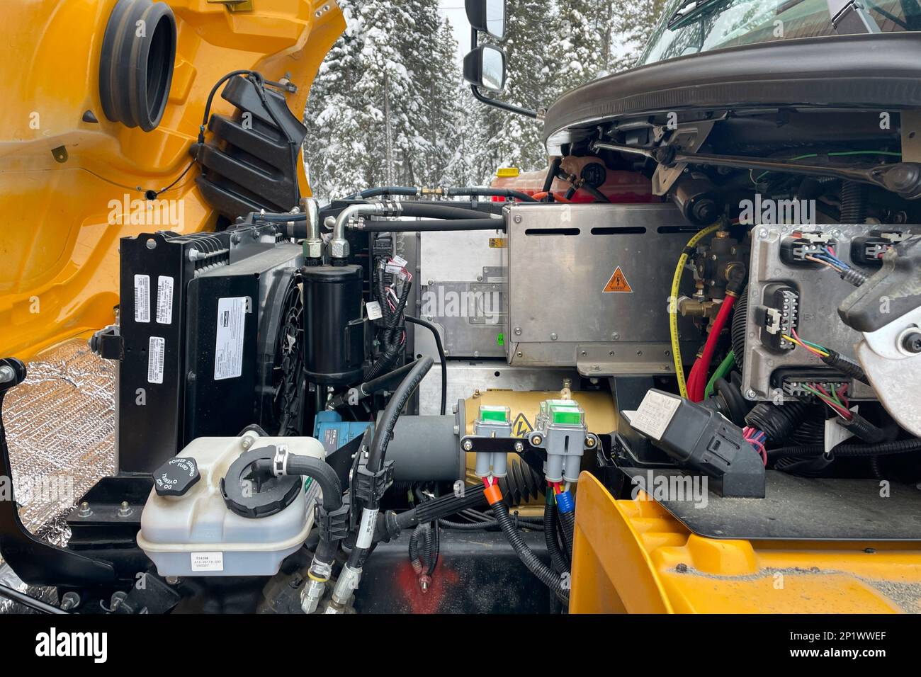An engine compartment is visible for an electric school bus operating ...