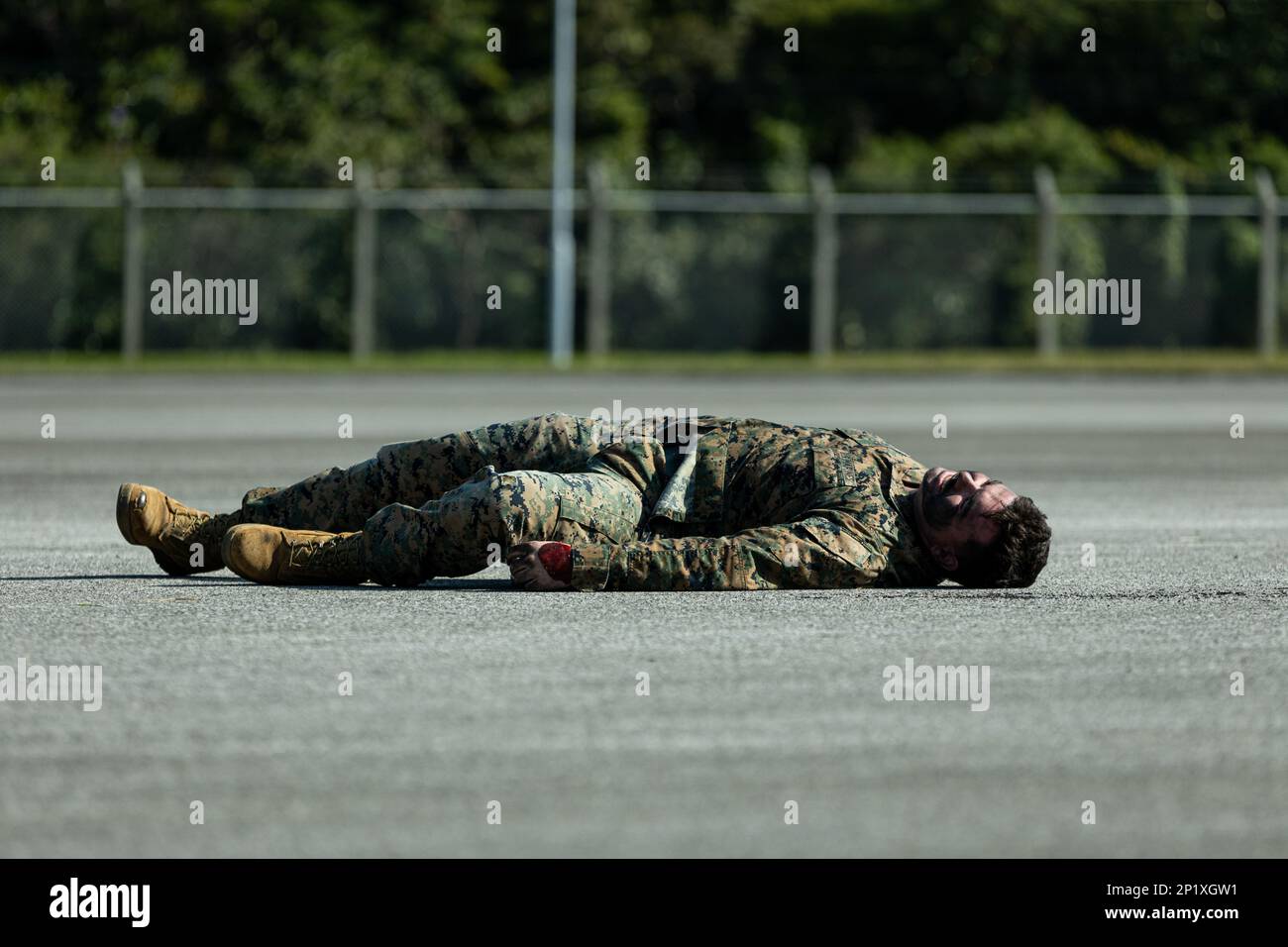 A U.S. Marine lies on the ground acting as a simulated casualty during ...