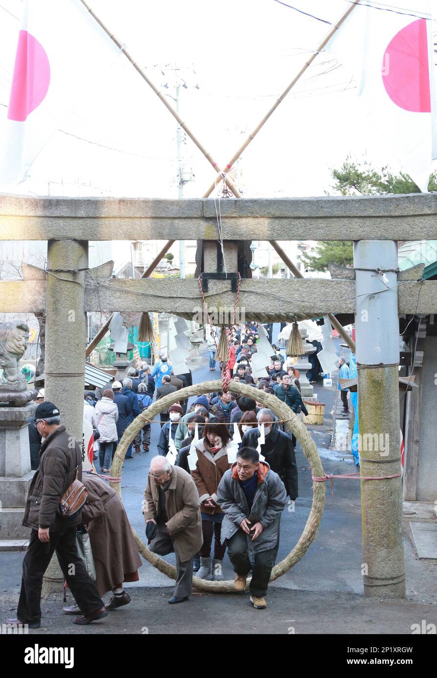People perform a Chinowa kuguri, passing through a ring made of kaya ...