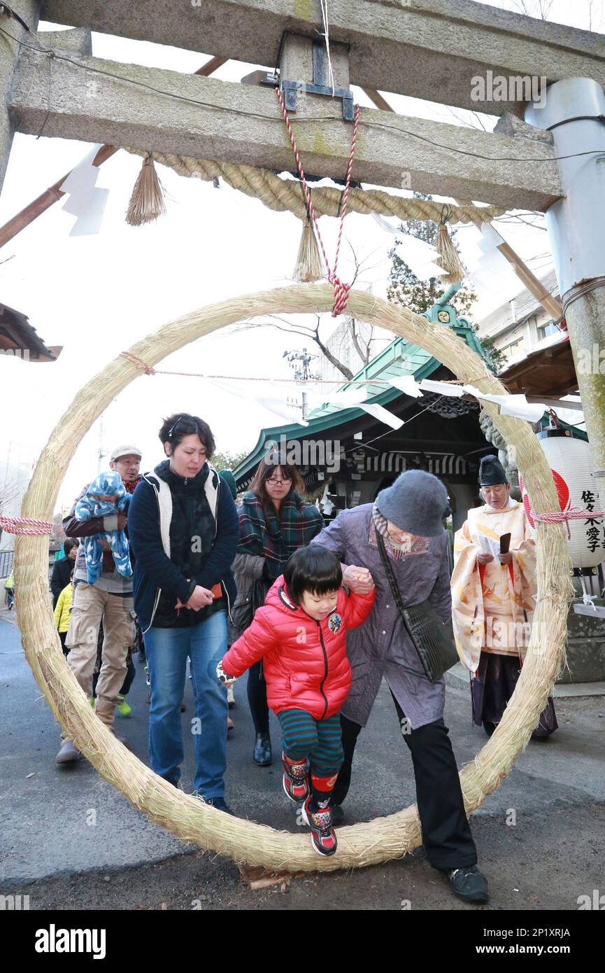 People perform a Chinowa kuguri, passing through a ring made of kaya ...