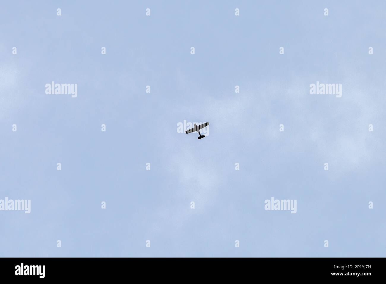 Light single-engine aircraft flies in blue sky on a daytime Stock Photo ...
