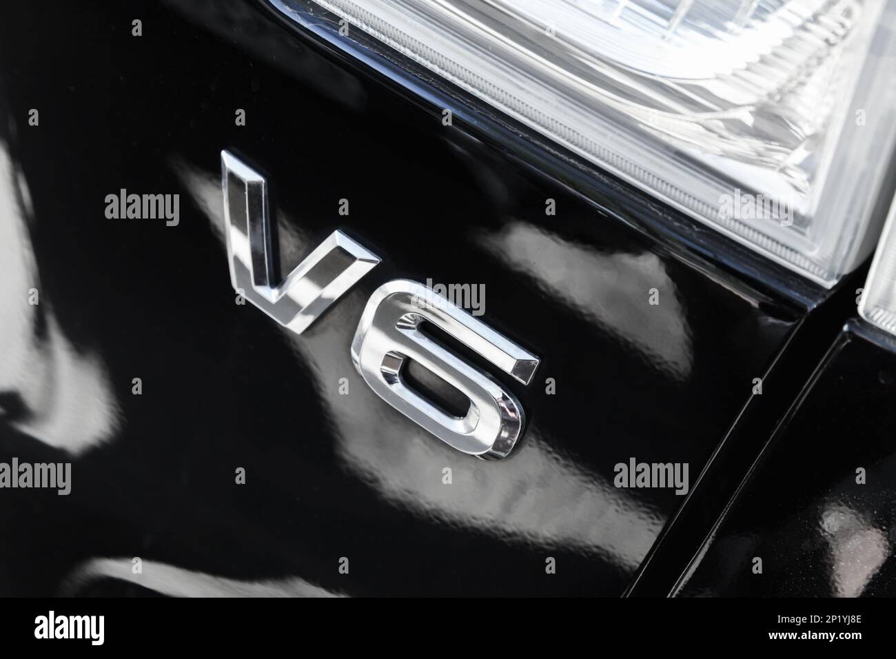 Shiny chrome V6 mark on black back car hood. High performance six ...