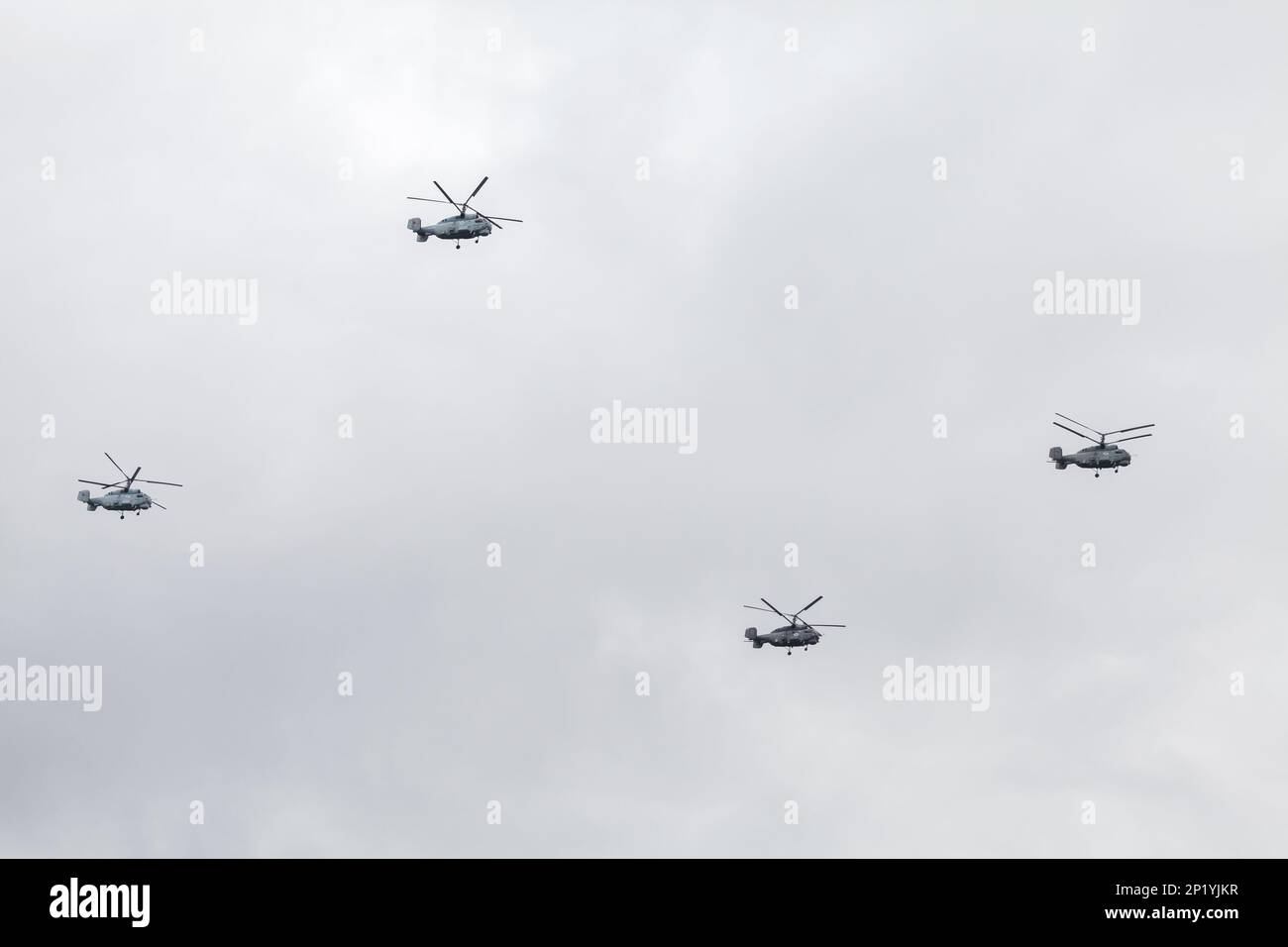 Four Kamov Ka-27 military Russian helicopters fly in cloudy sky on a ...