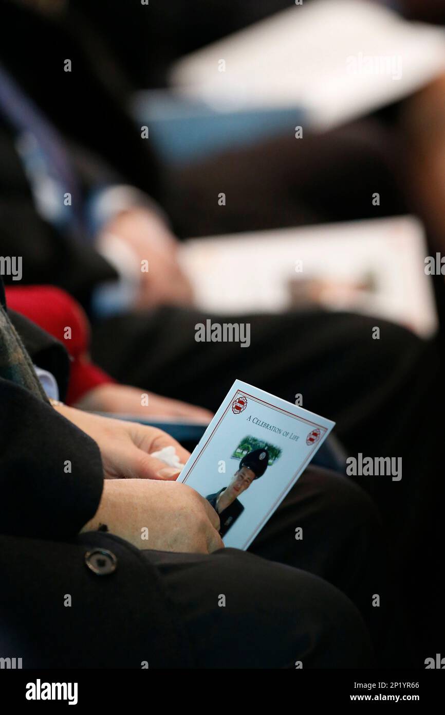 A mourner holds a program during the funeral service for Chicago ...