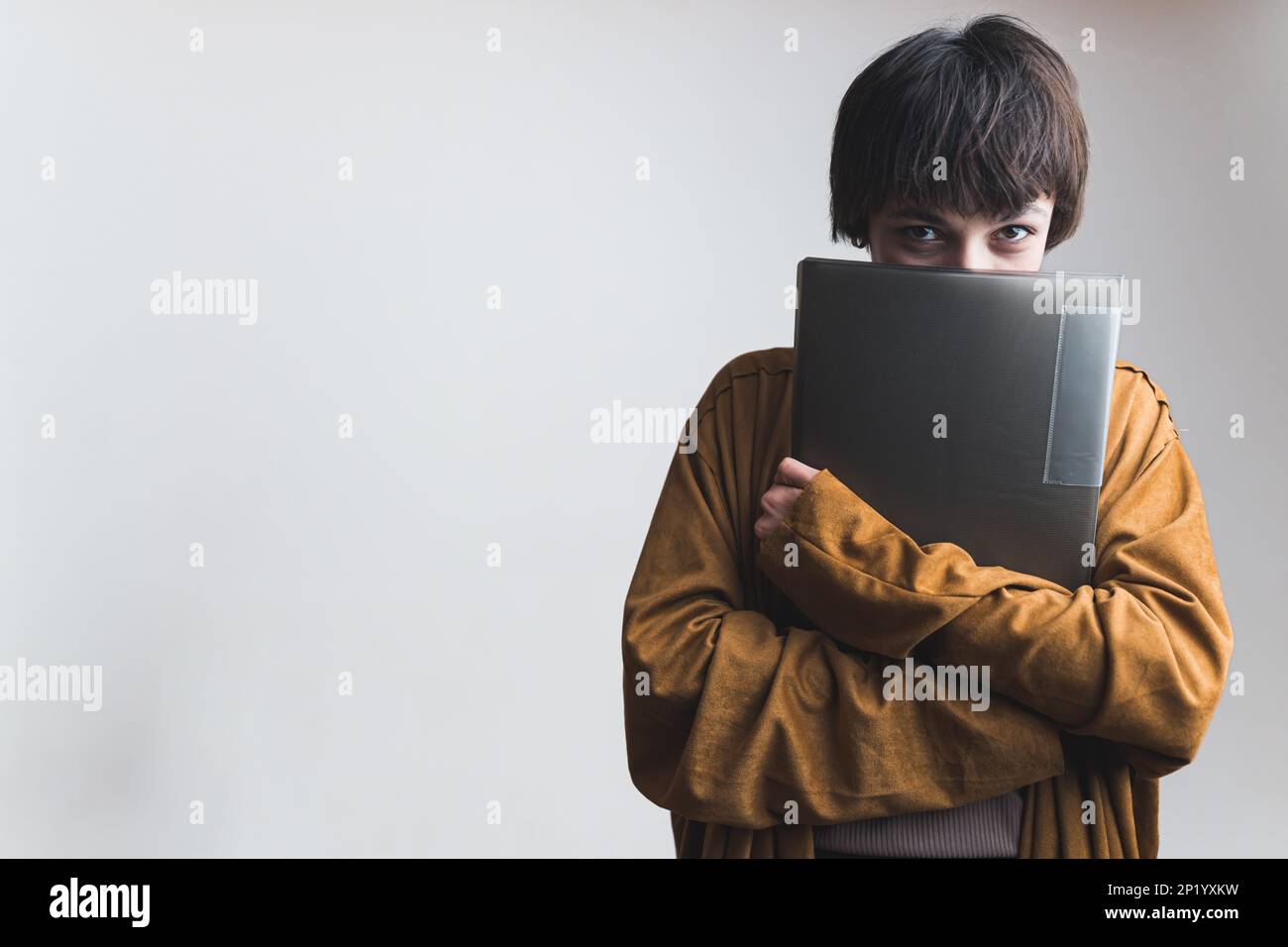 Medium shot of a woman standing to the right covering her face with a ...