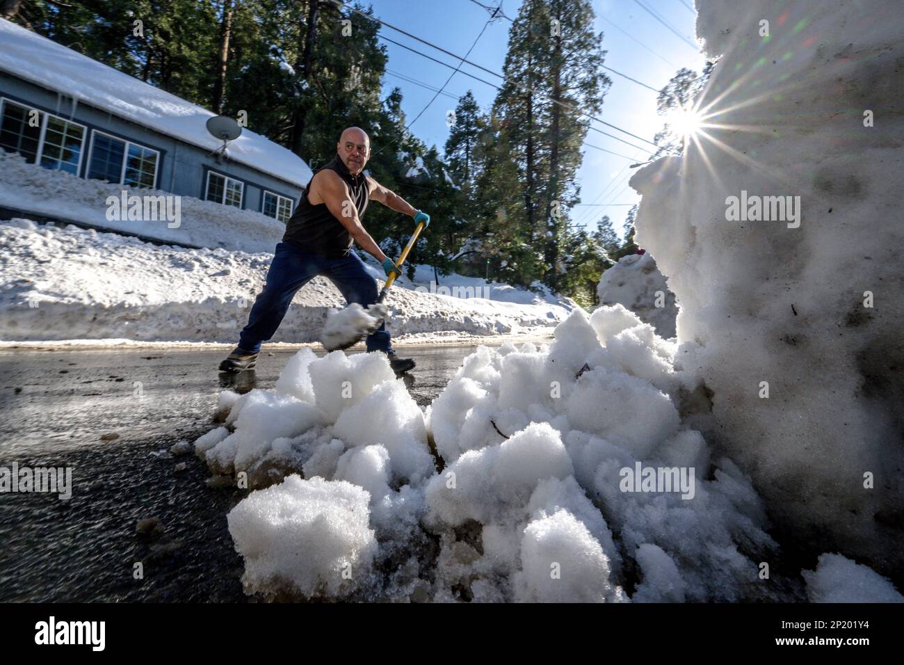 Michael Romero clears snow in front of his home, where his three ...