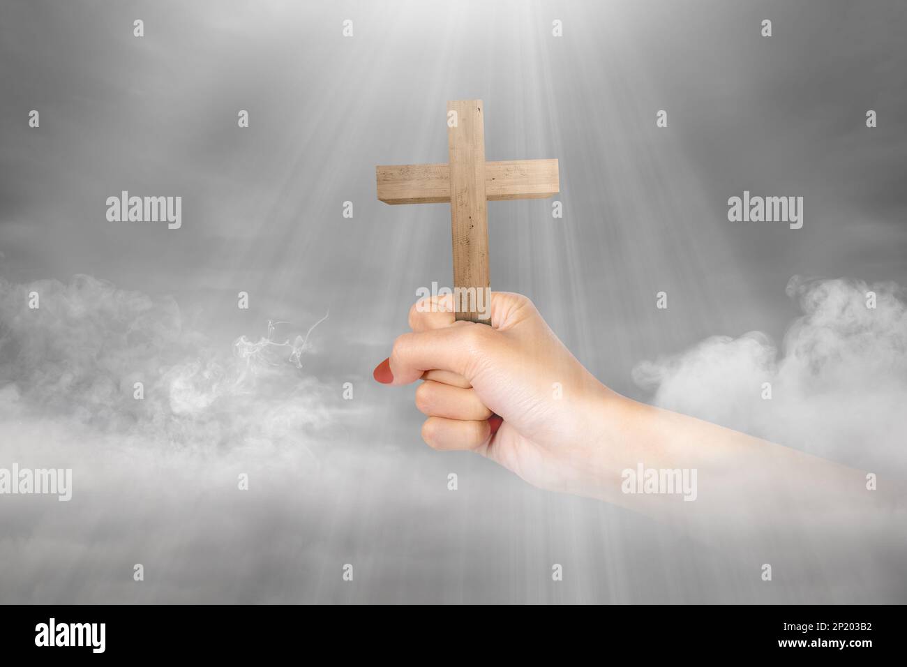 Human hand holding Christian cross with light background Stock Photo ...