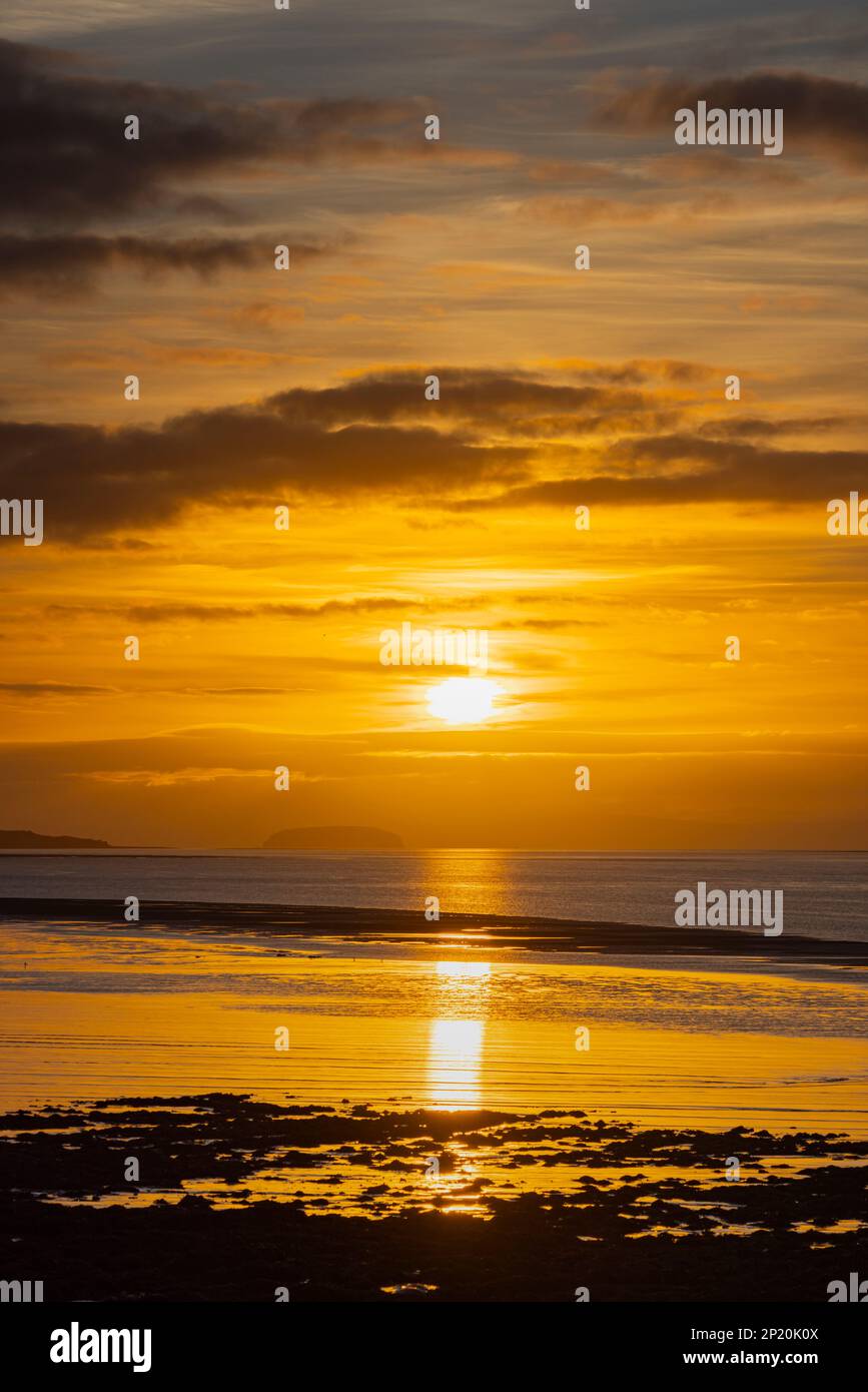 The sun setting over the Bristol channel with a golden glow along the ...