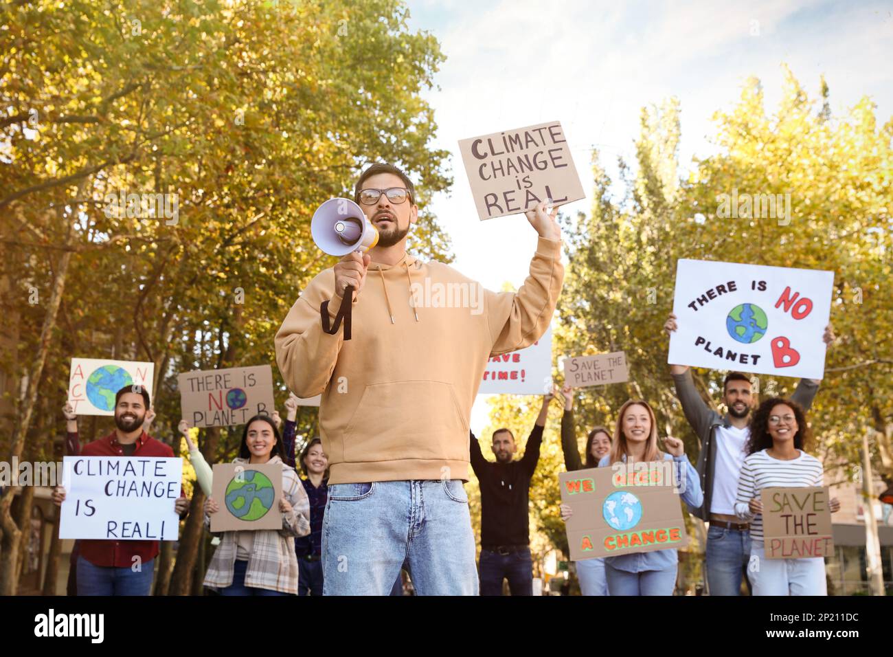 Group of people with posters protesting against climate change outdoors ...