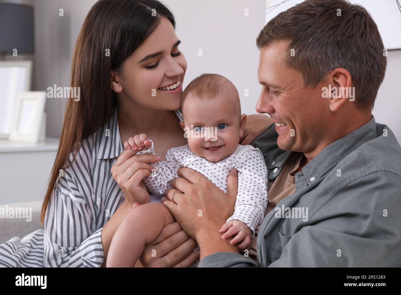 Happy family with their cute baby at home Stock Photo - Alamy