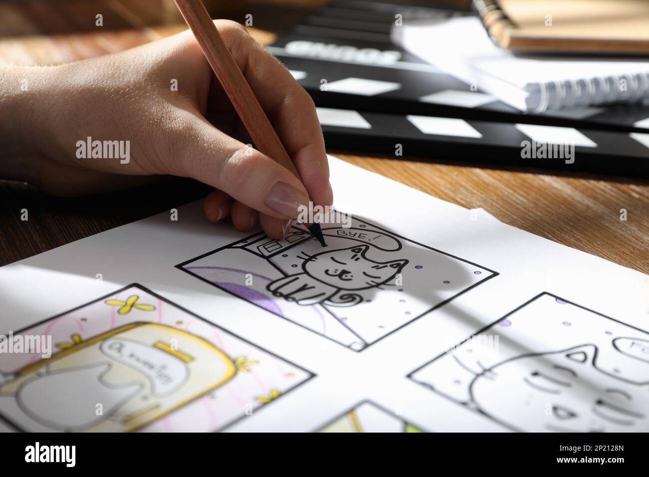 Woman drawing cartoon sketch at workplace, closeup. Pre-production ...