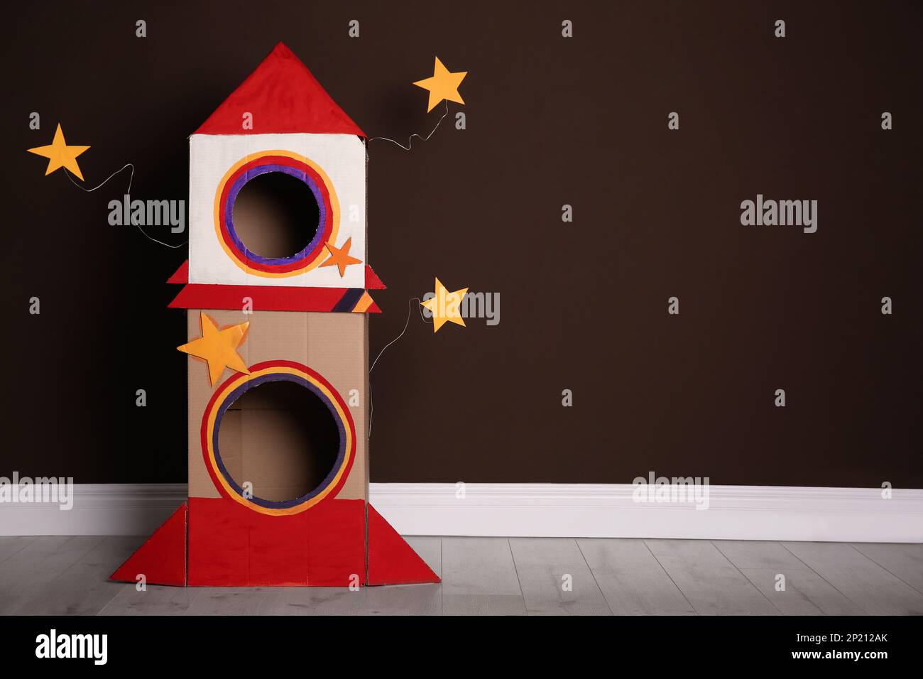 Cute handmade cardboard spaceship near brown wall. Space for text Stock ...