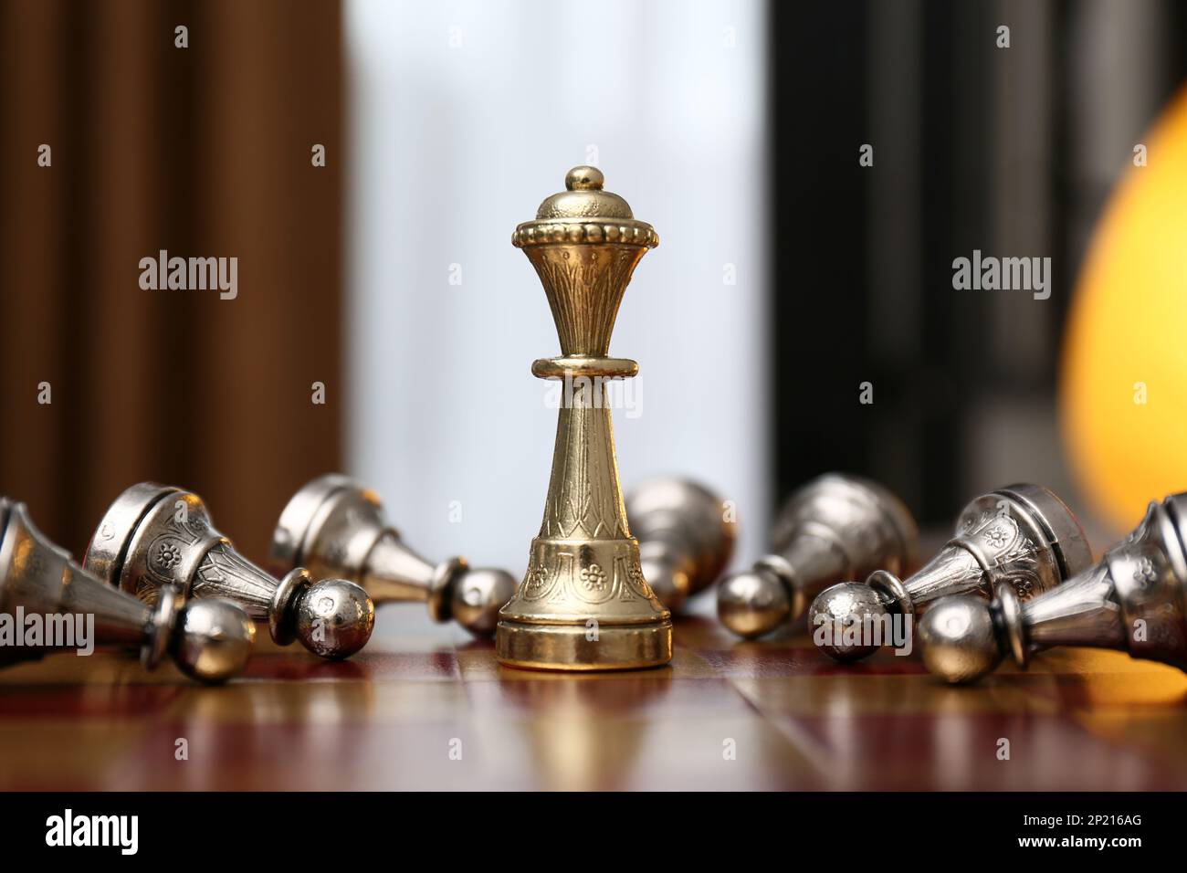 Queen piece among defeated pawns on chessboard indoors Stock Photo - Alamy