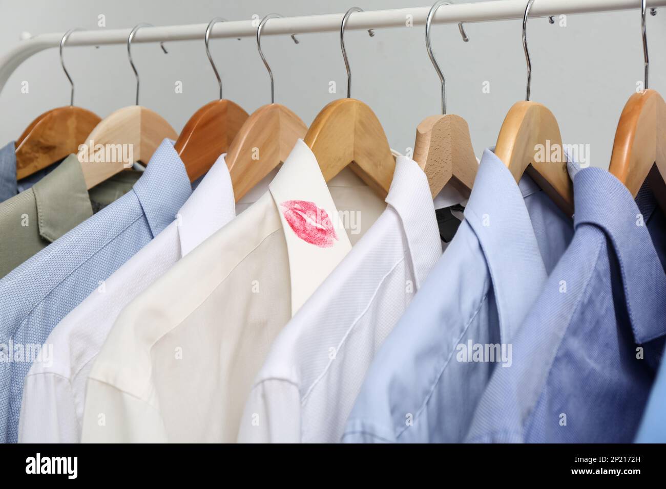Men's shirts and one with lipstick kiss mark on rack, closeup Stock ...