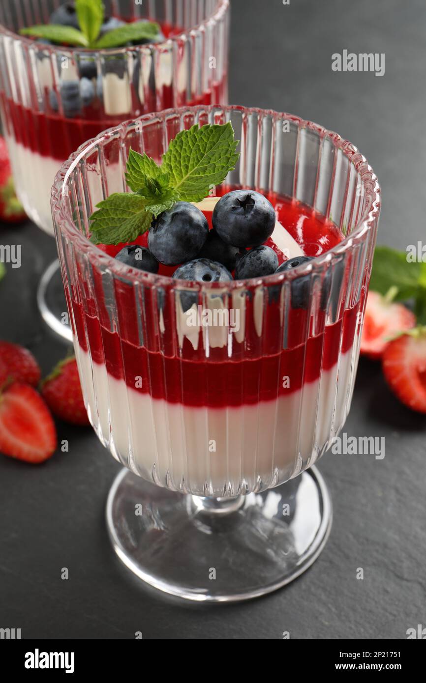 Delicious panna cotta with fruit coulis and fresh berries on dark grey ...
