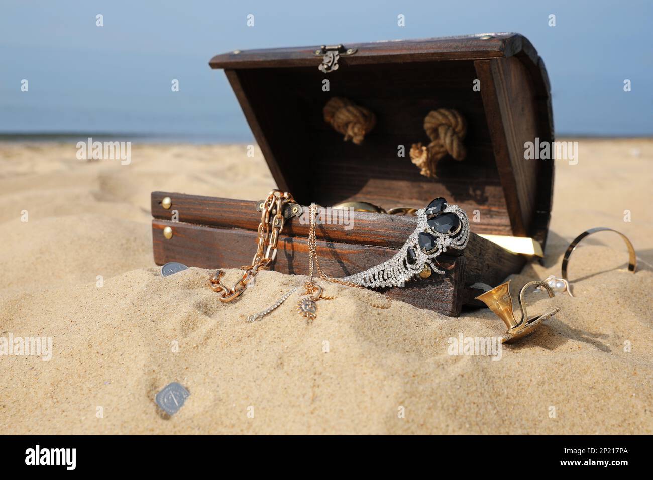 Open wooden treasure chest on sandy beach Stock Photo - Alamy