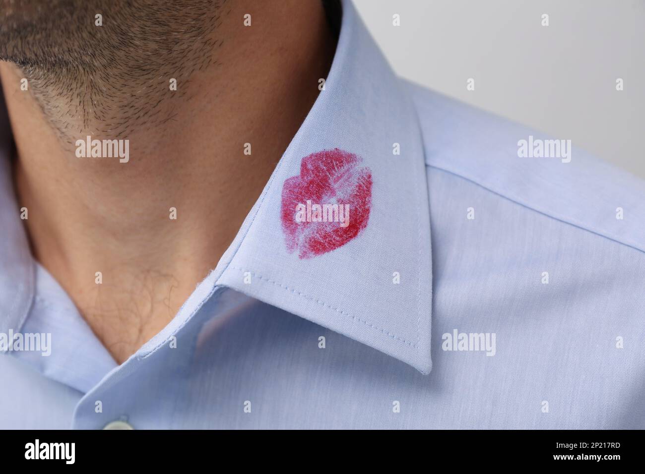 Man in shirt with lipstick kiss mark on white background, closeup Stock ...