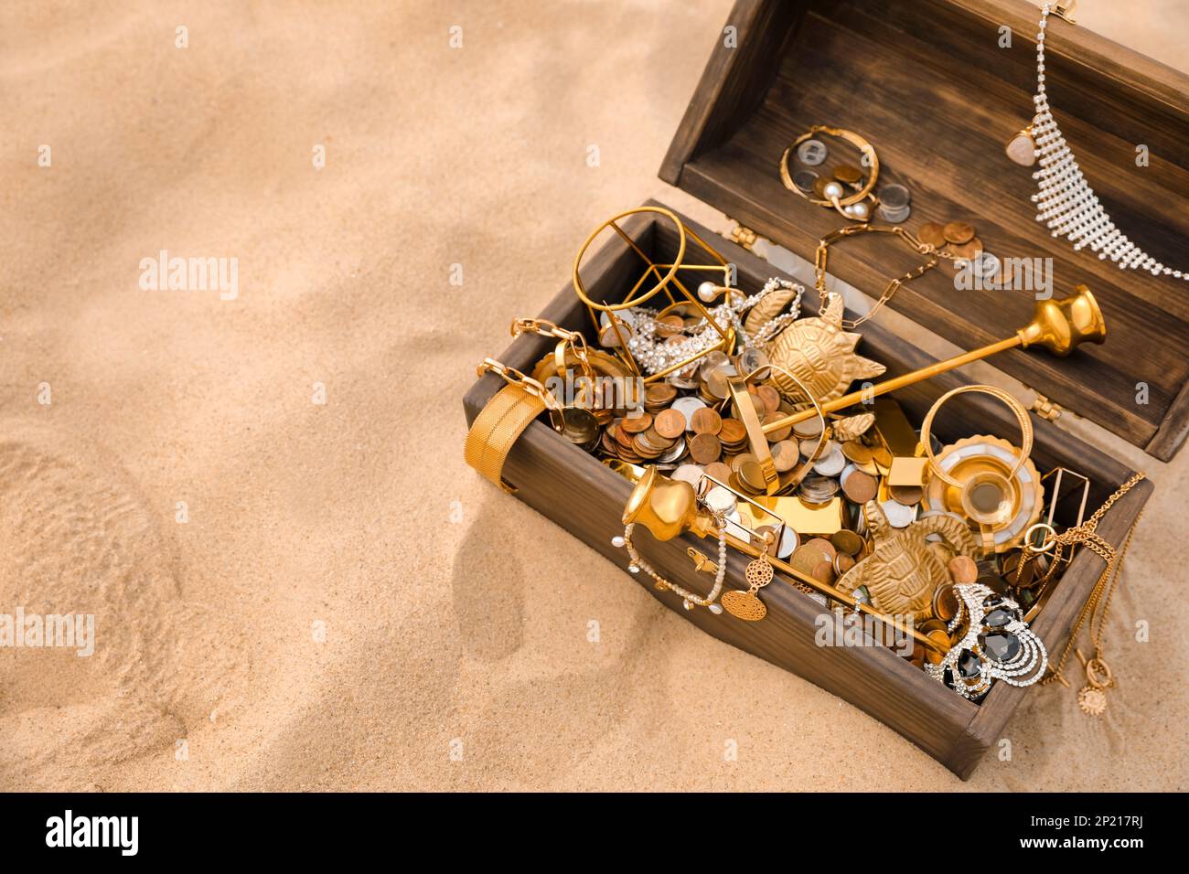 Open wooden treasure chest on sand, above view. Space for text Stock ...