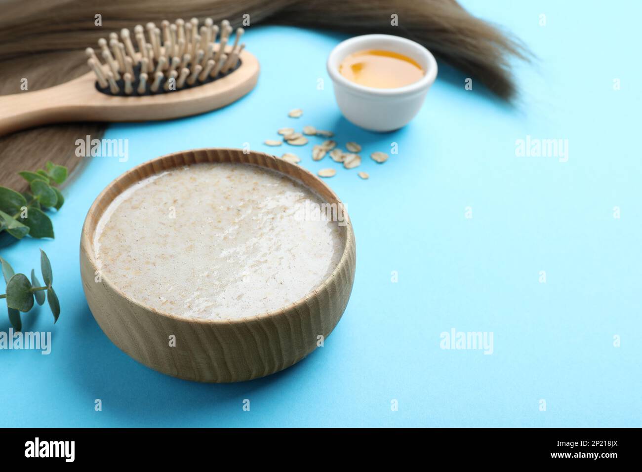 Homemade hair mask, ingredients and brush on light blue background ...