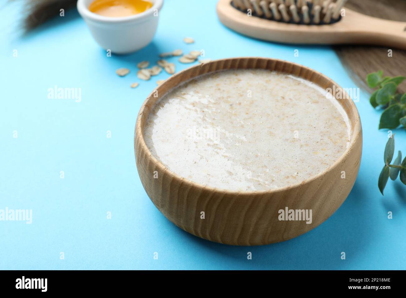 Homemade hair mask, ingredients and brush on light blue background ...