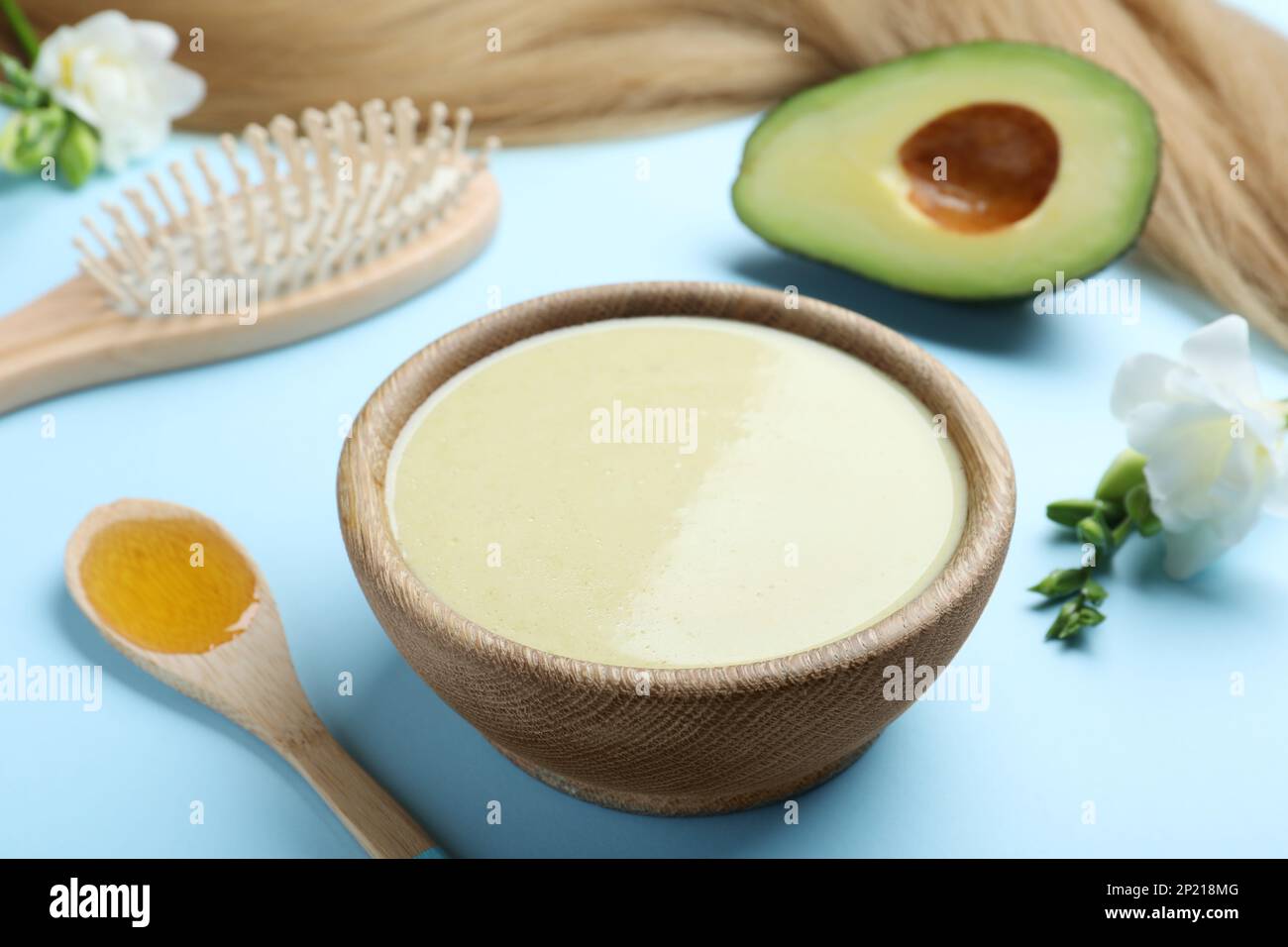 Homemade hair mask, ingredients and brush on light blue background ...