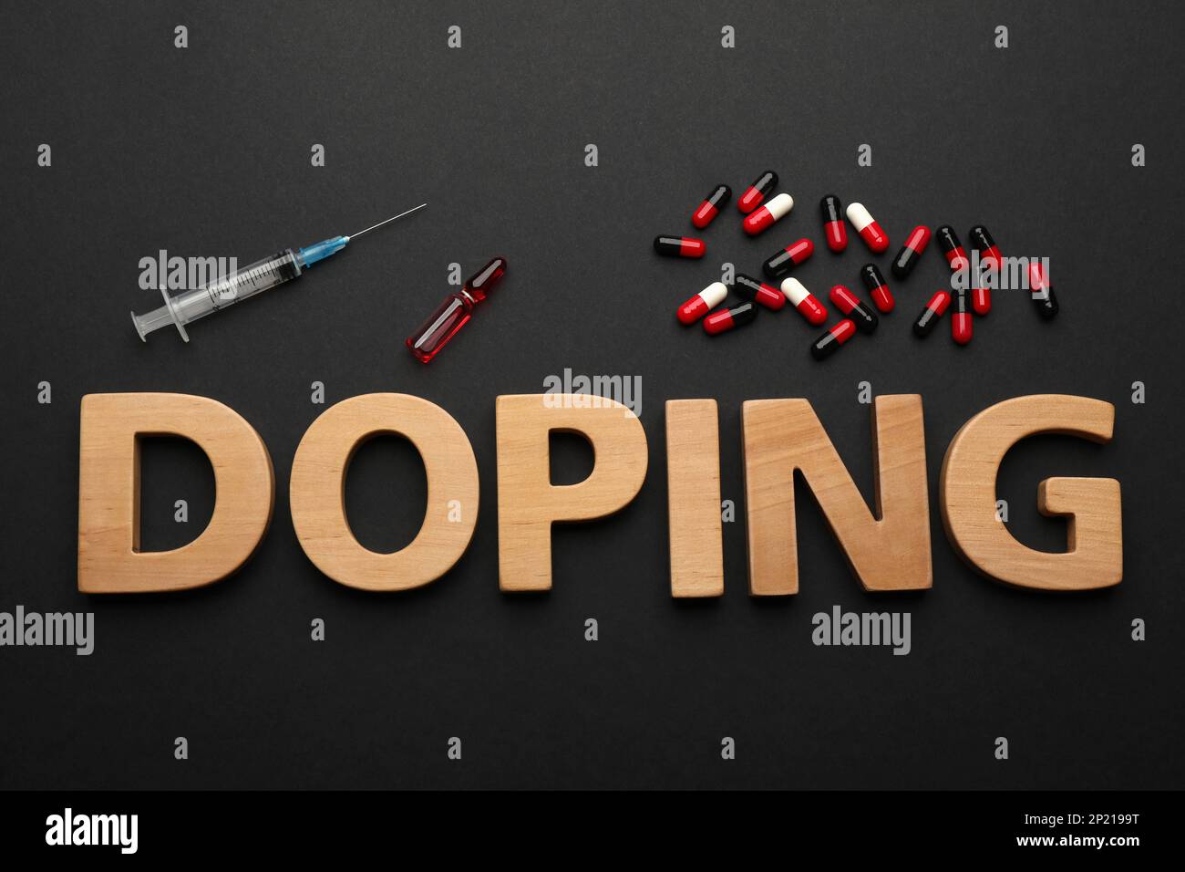 Word Doping of wooden letters with drugs on black background, flat lay ...