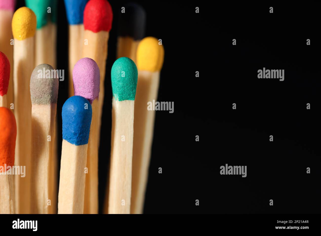 Matches with colorful heads on black background, closeup. Space for ...