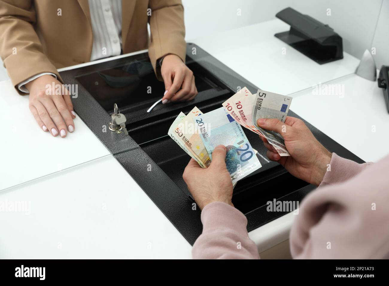 Man exchanging money in bank, closeup view Stock Photo - Alamy