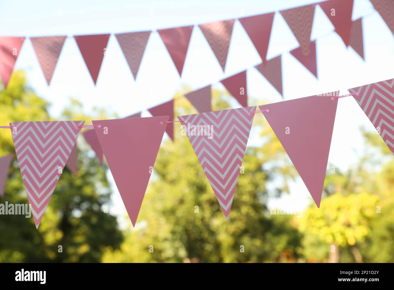 Pink bunting flags in park. Party decor Stock Photo - Alamy