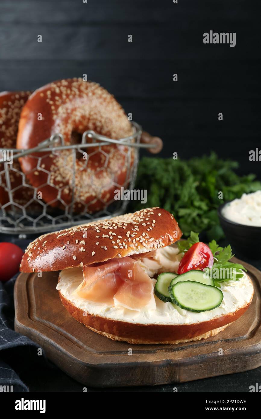 Delicious bagel with cream cheese, jamon, cucumber, tomato and parsley ...