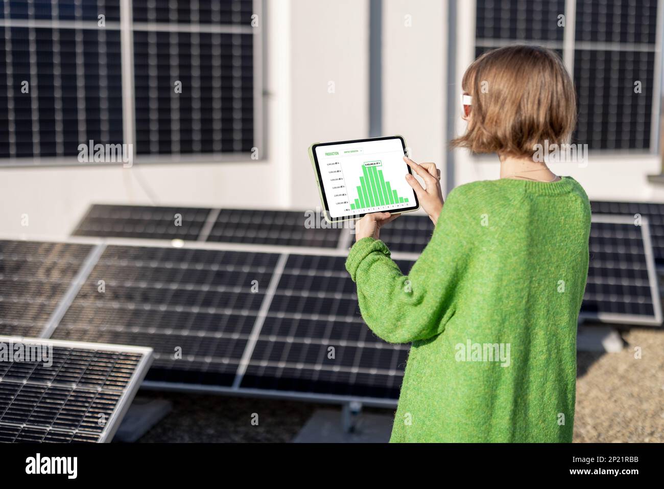 Woman monitors energy production from the solar power plant with a ...