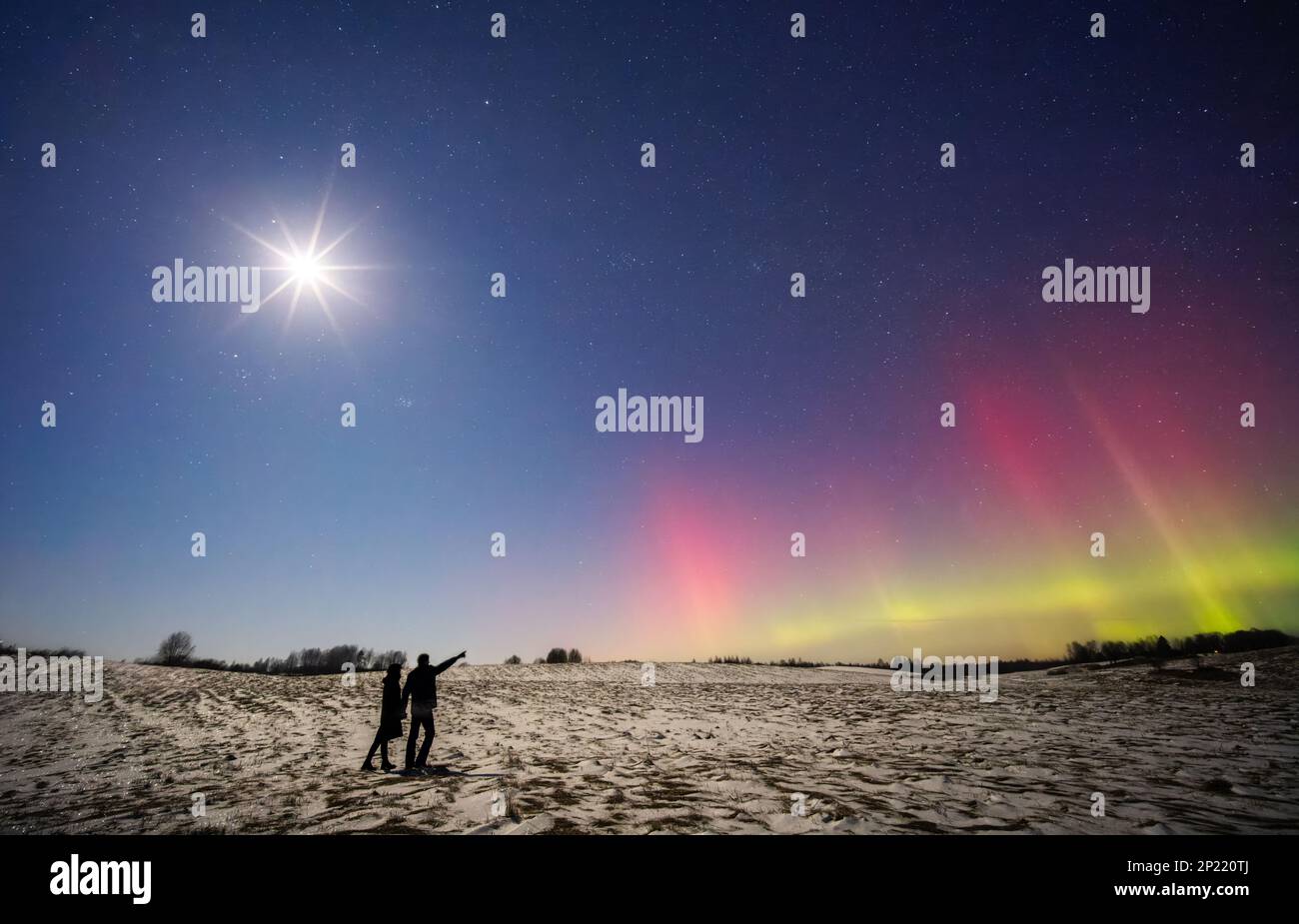 Northern lights - Aurora borealis dancing in the night sky. Couple ...