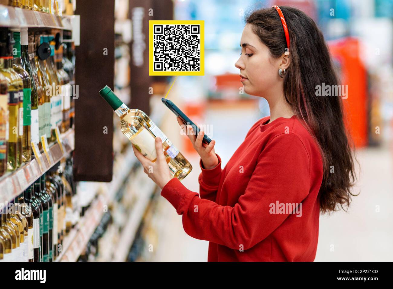 A young Caucasian woman scans the qr code on a wine bottle using her ...
