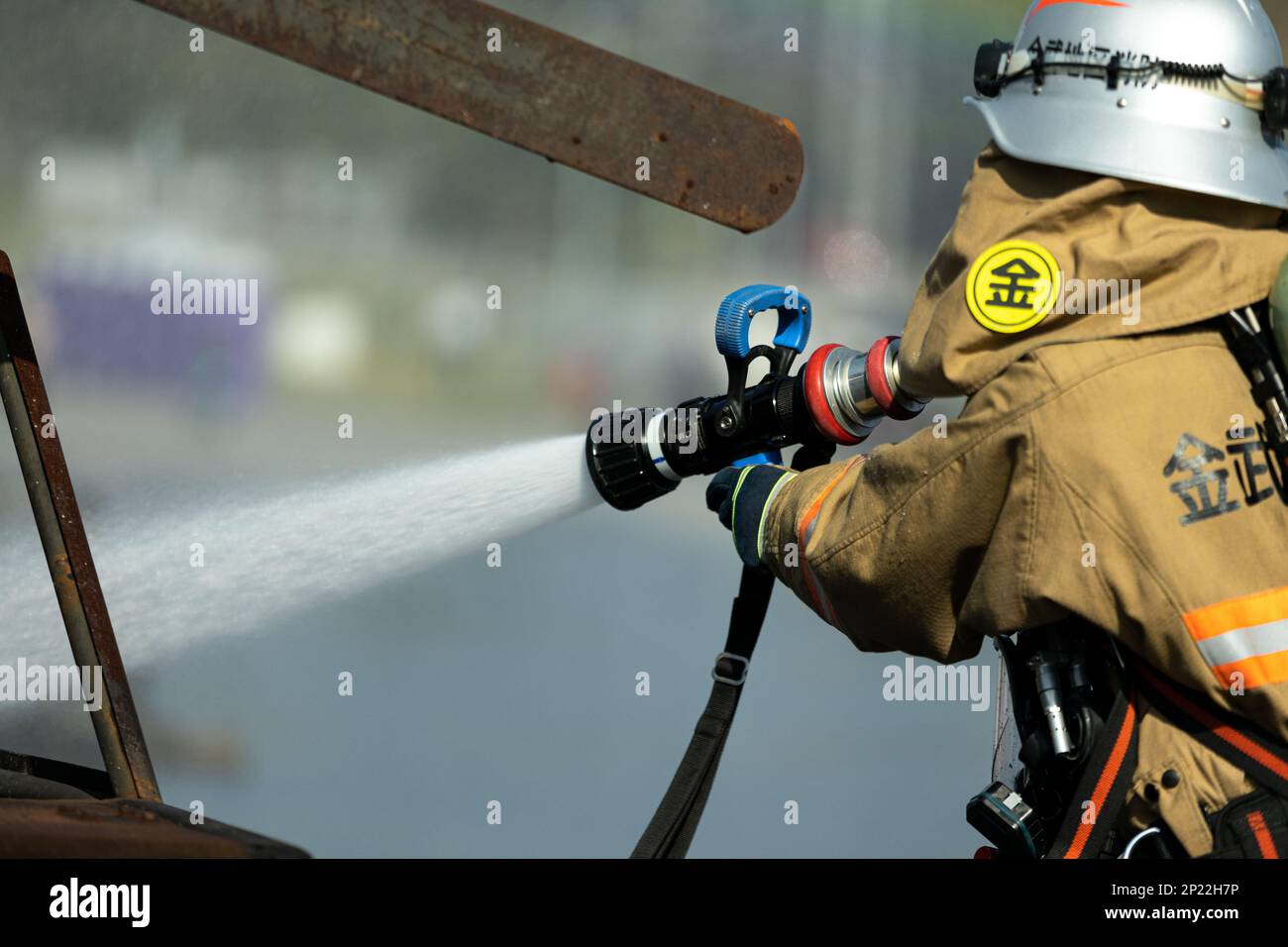 A firefighter with the Kinchiku Fire Department extinguishes a fire ...