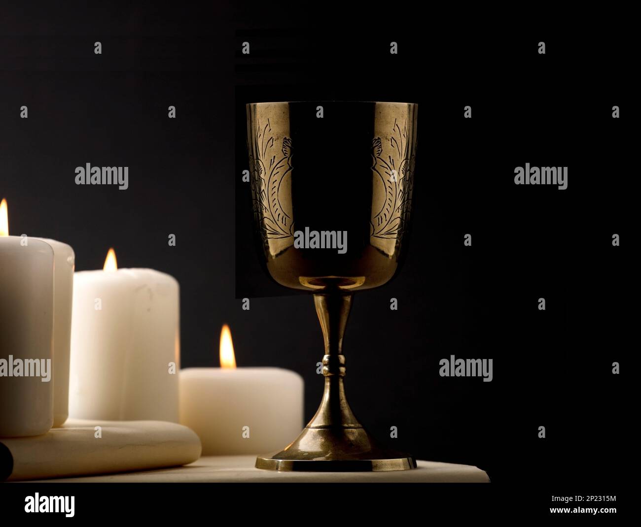 golden christian chalice with burning candles on beige altar black ...