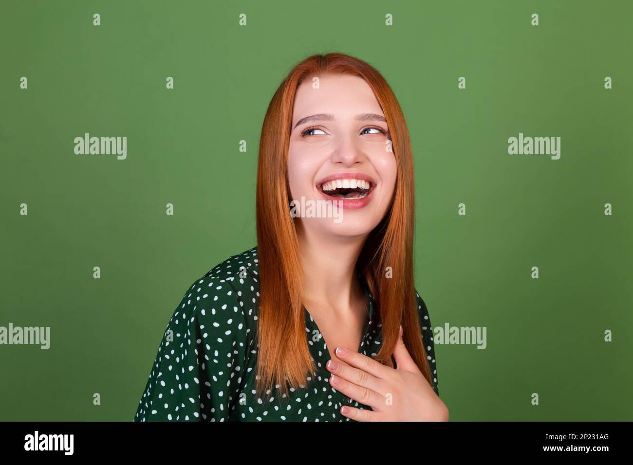 Young red hair woman on green background smile and laugh, in good mood ...