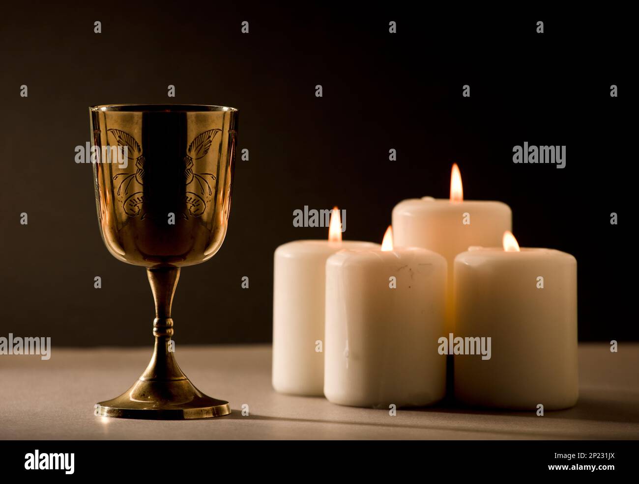 Old romantic wine glass, chalice, with candles, dark gray background ...