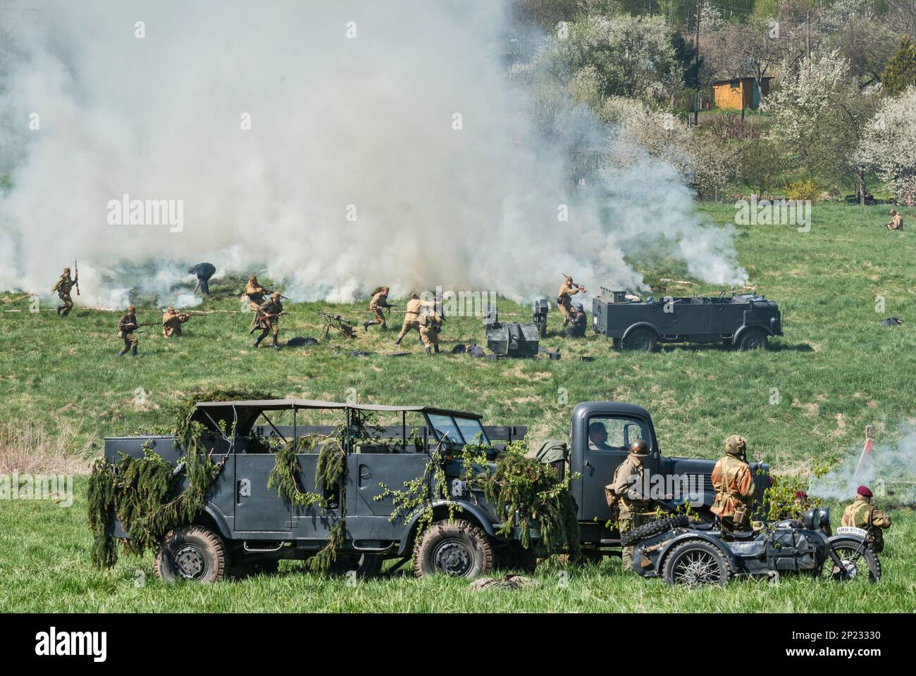 German military trucks, troops, under fire, at reenactment of WW2 ...