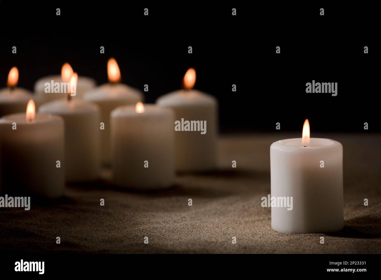 bullying concept, composed by group of lit candles, on sand with black ...