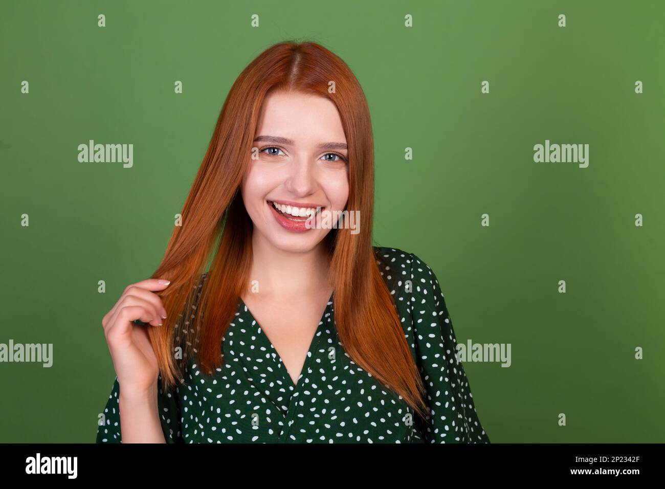 Young red hair woman on green background smile and laugh, in good mood ...