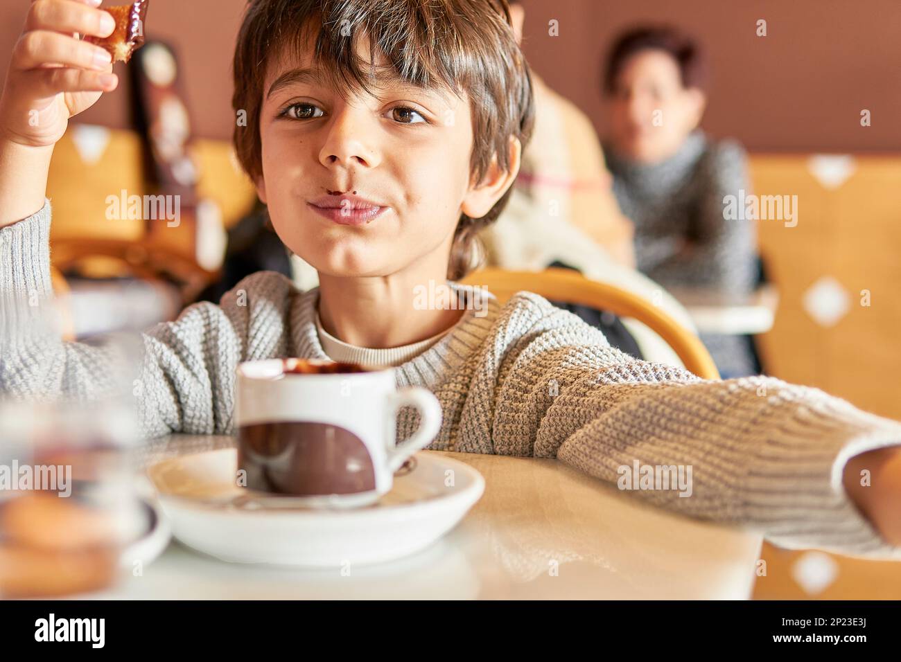kid eating churros and chocolate on a crowded bar Stock Photo - Alamy